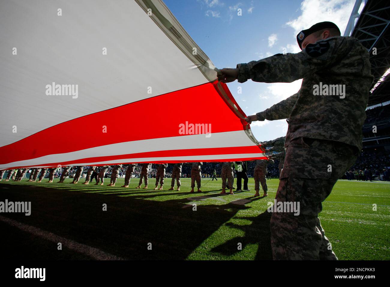 Recently returned from combat soldiers hold the American flag, in honor ...