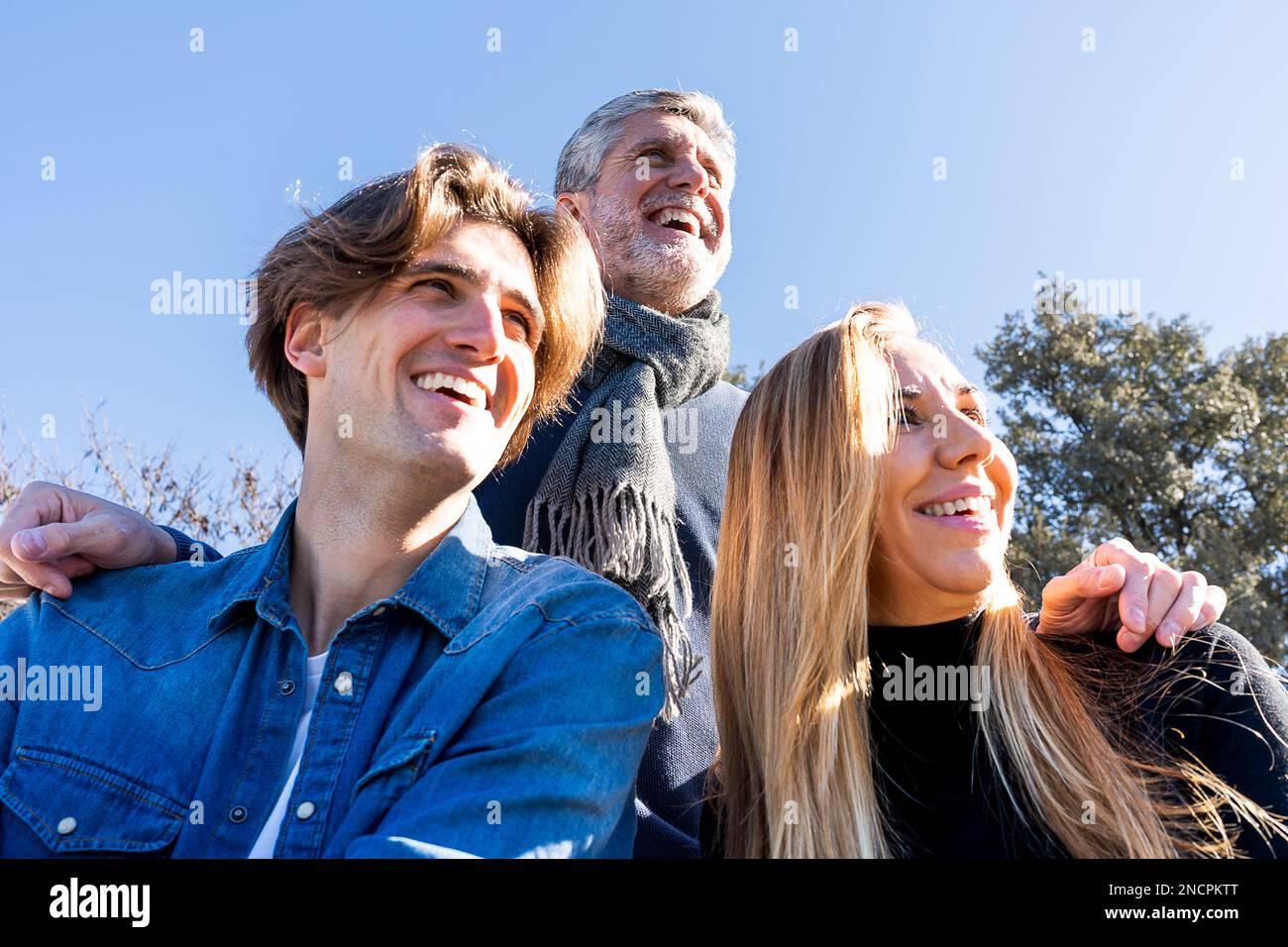 Low angle of young man in denim jacket spending free time with mature ...