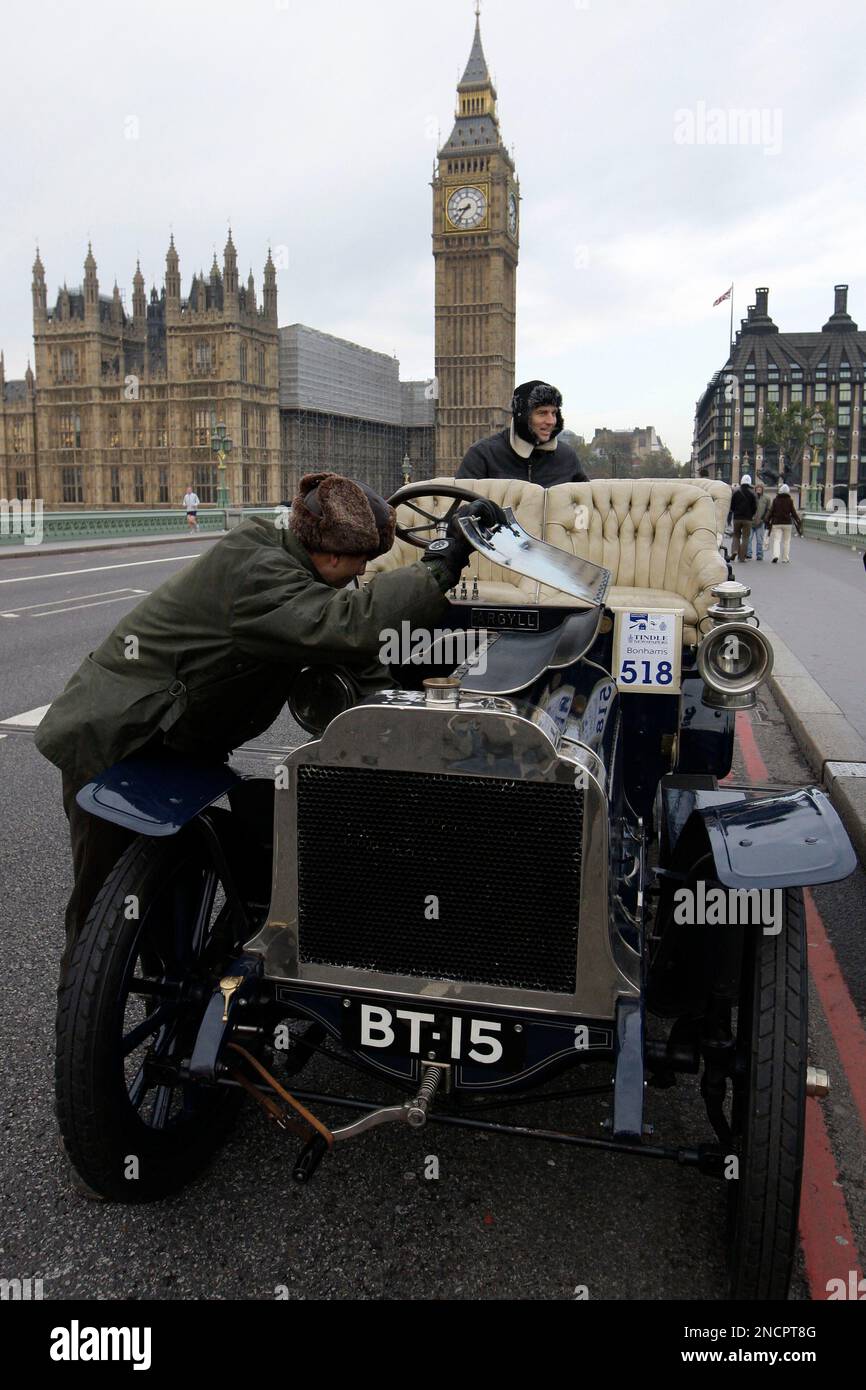 The driver checks the engine of his 1904 Argyll on Westminster Bridge ...