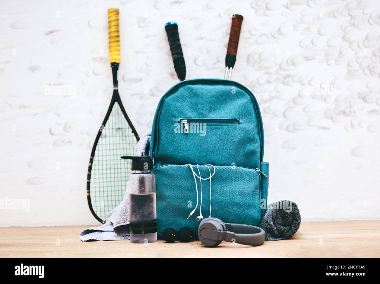 Ready, setsquash. a sports bag and other items in an empty squash court ...