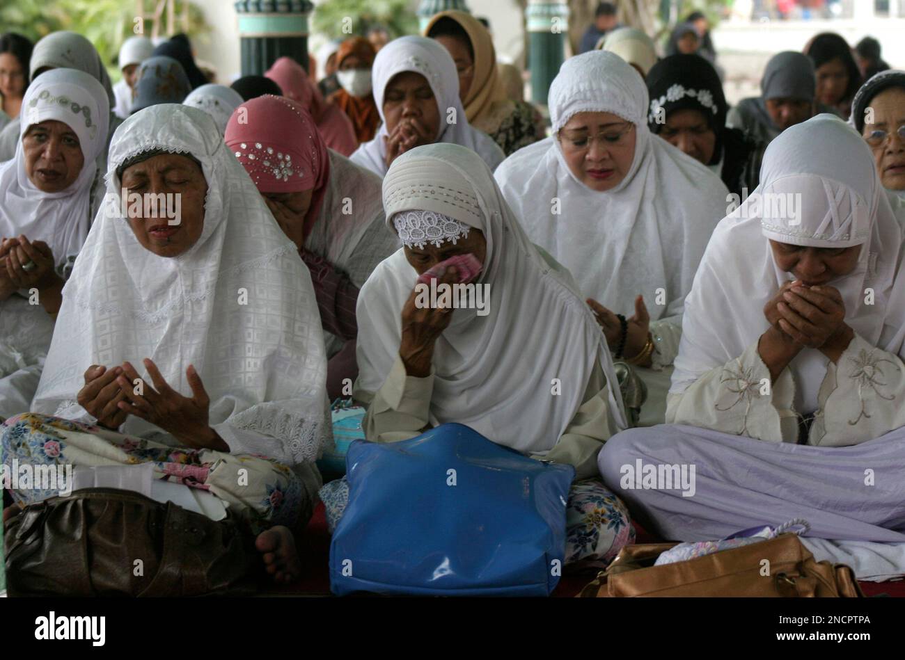 Muslim women weep during a prayer for the victims of the eruption of ...