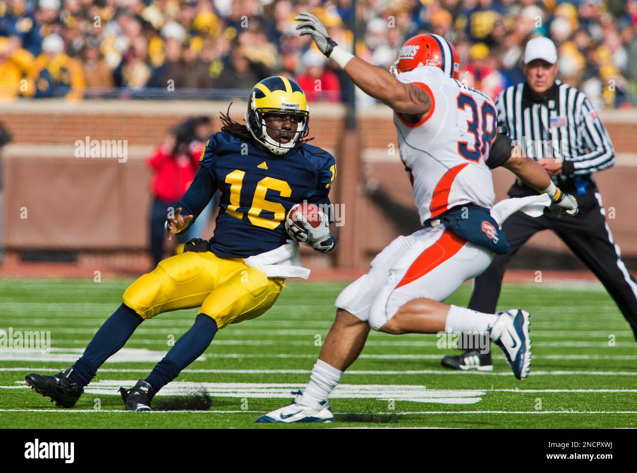 Michigan quarterback Denard Robinson (16) tries to evade Illinois ...