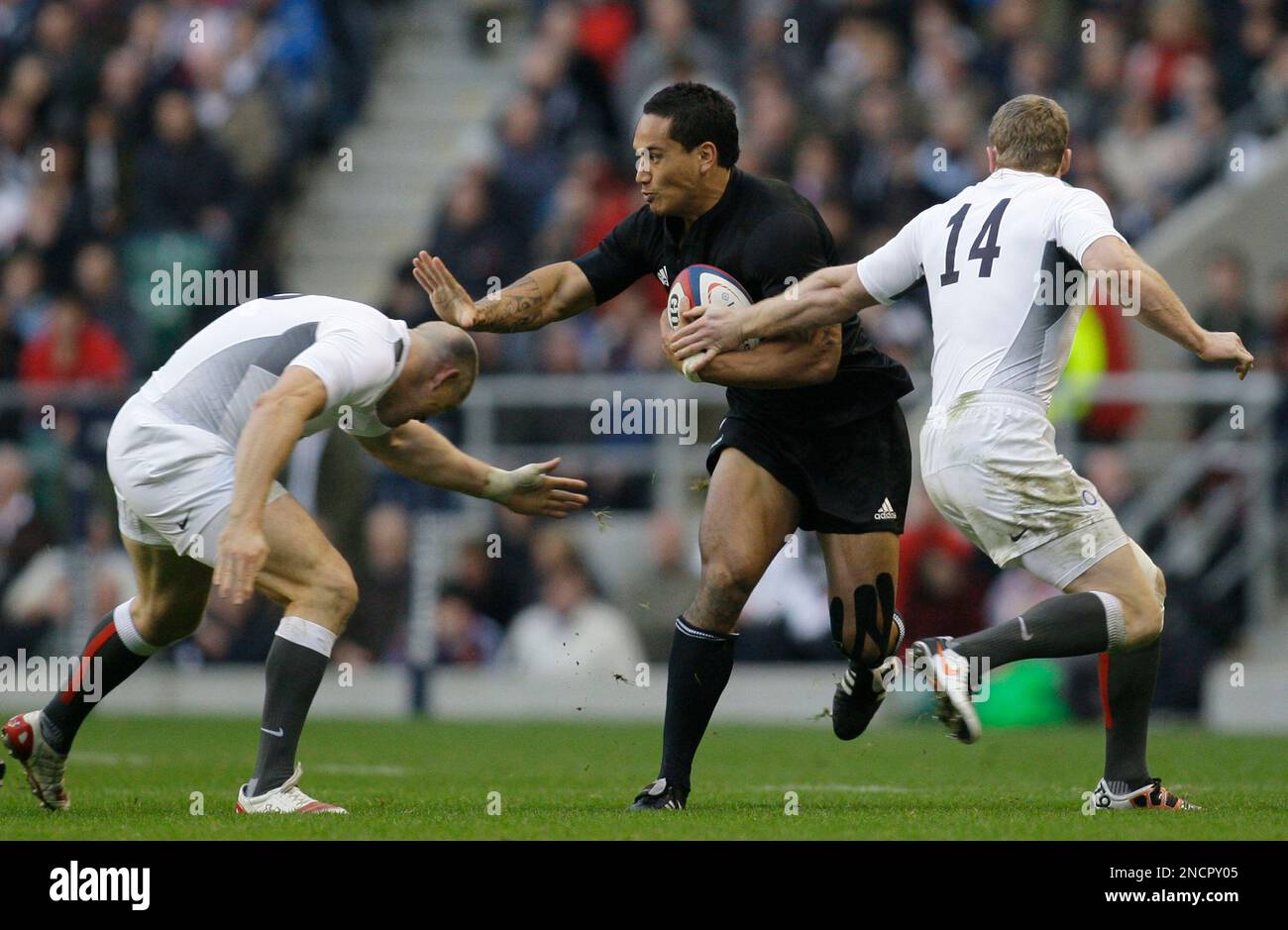 New Zealand's Hosea Gear, center, is tackled by England's Mike Tindall ...