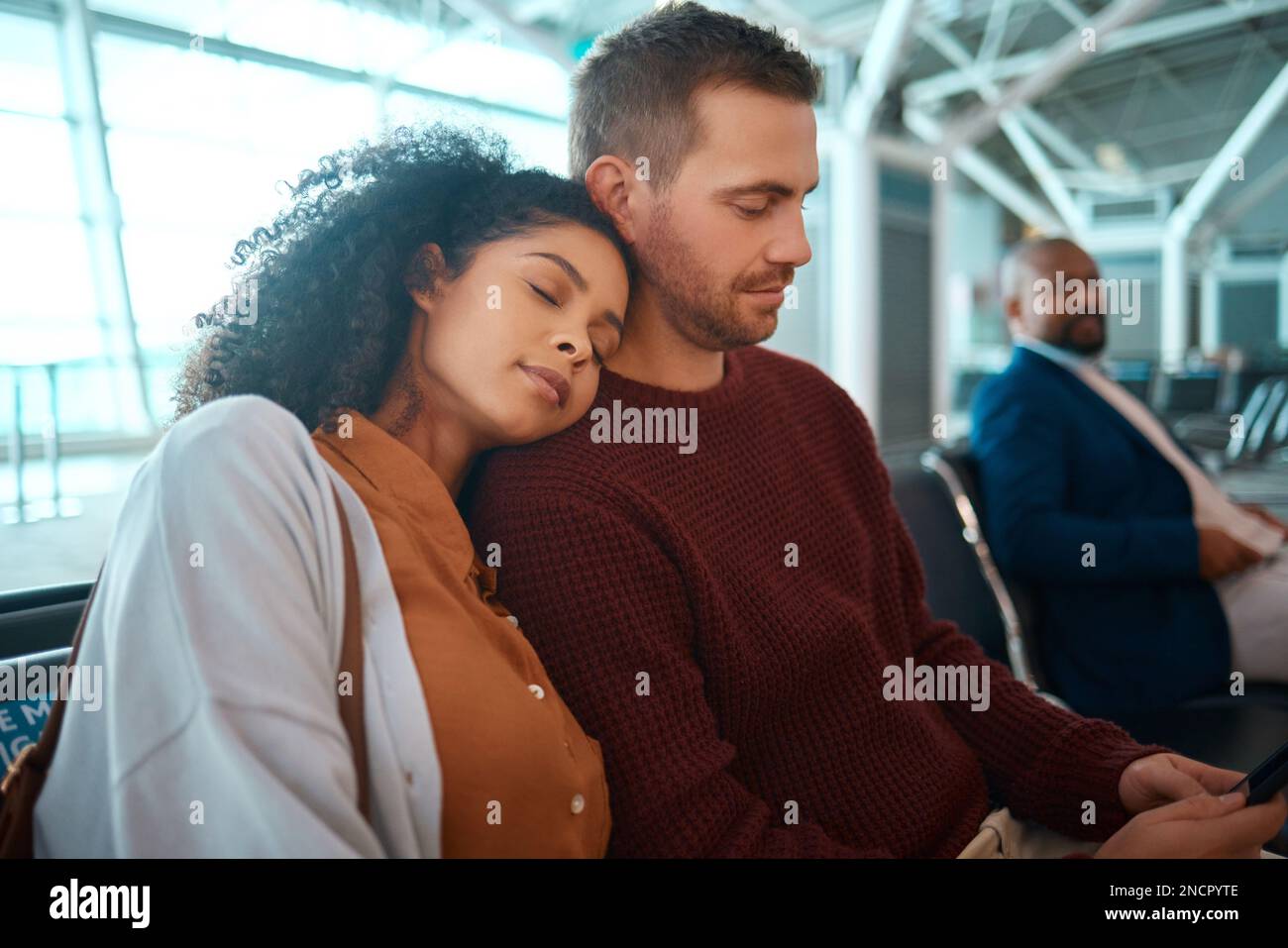 Airport, travel and woman sleeping by her boyfriend while waiting to board their flight together ...