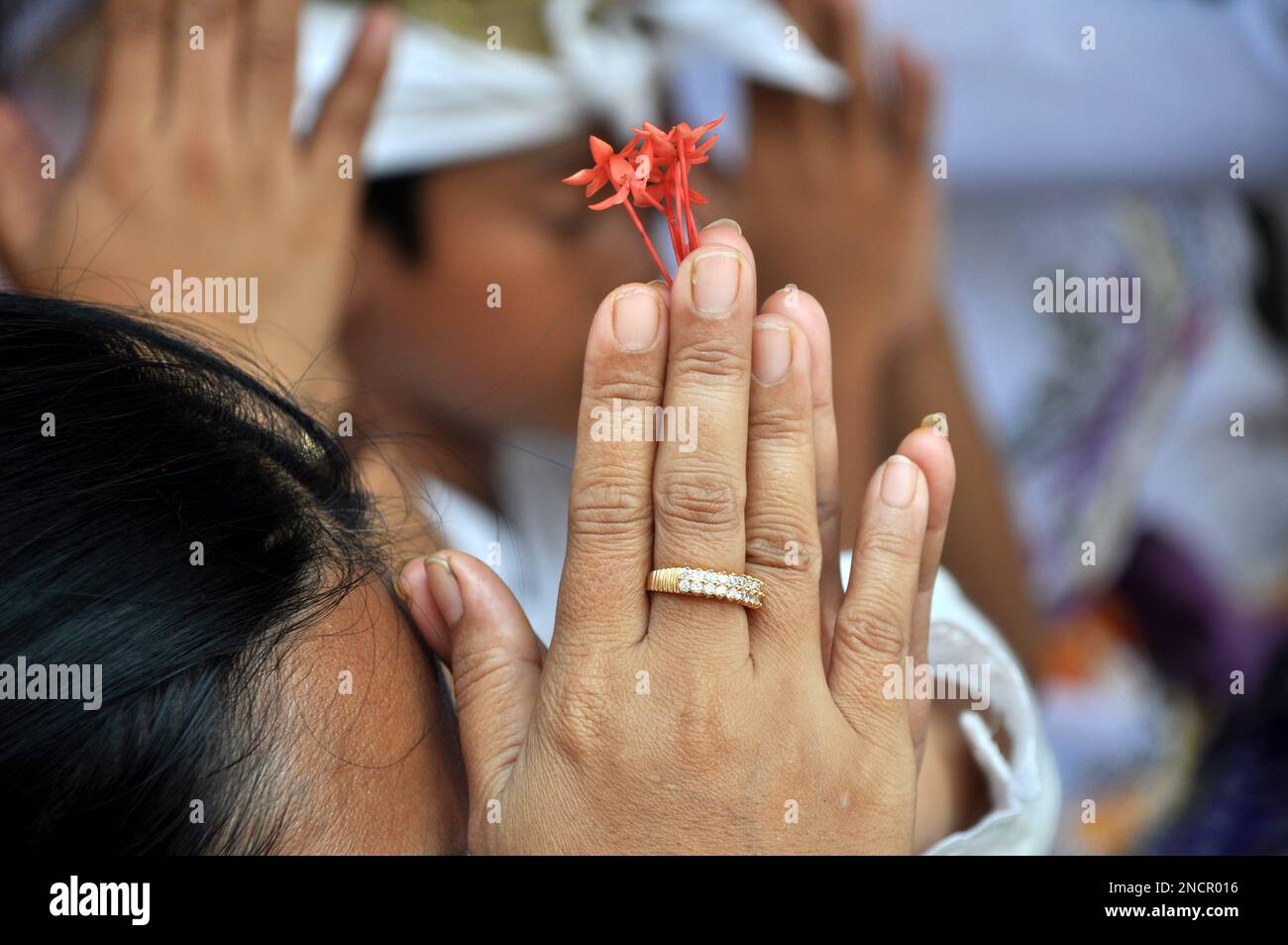 Position of hands clasping flowers in hindu prayer Stock Photo - Alamy