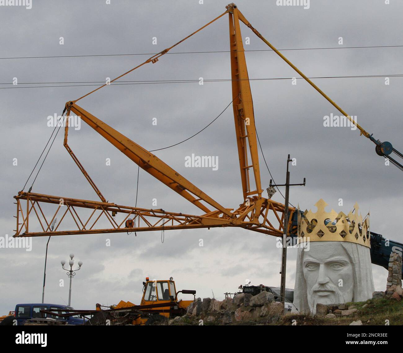 Workers struggling against wind to assemble a crane that is to lift 32 ...