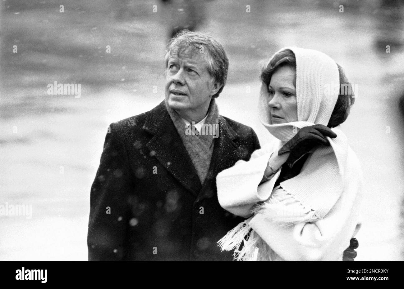 President Jimmy Carter and first lady Rosalynn Carter stand in the snow ...
