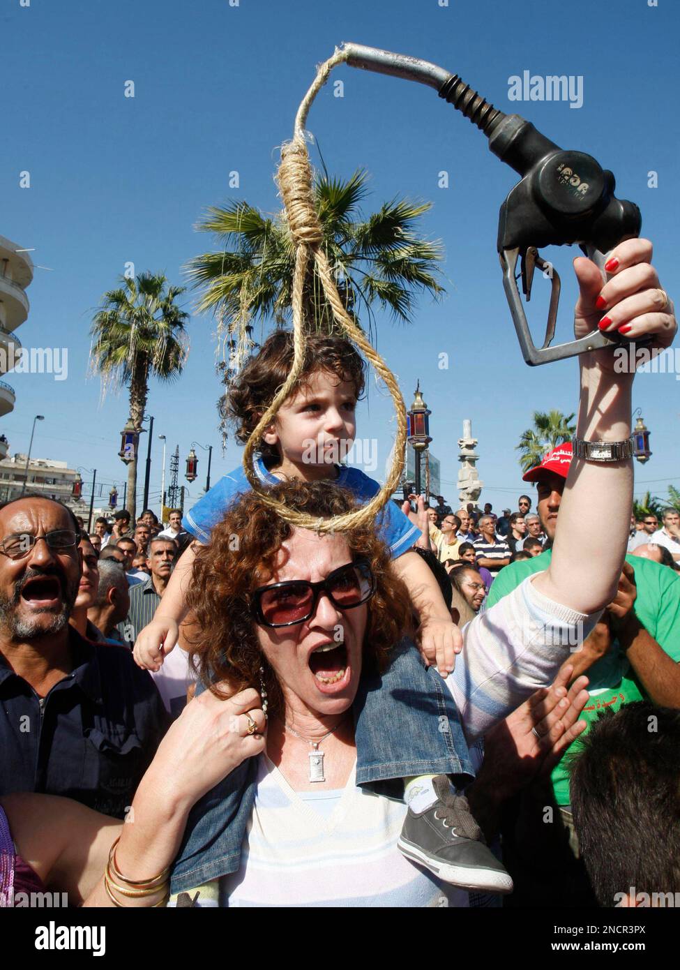 A Lebanese woman carries her son on her shoulders, as she shouts ...