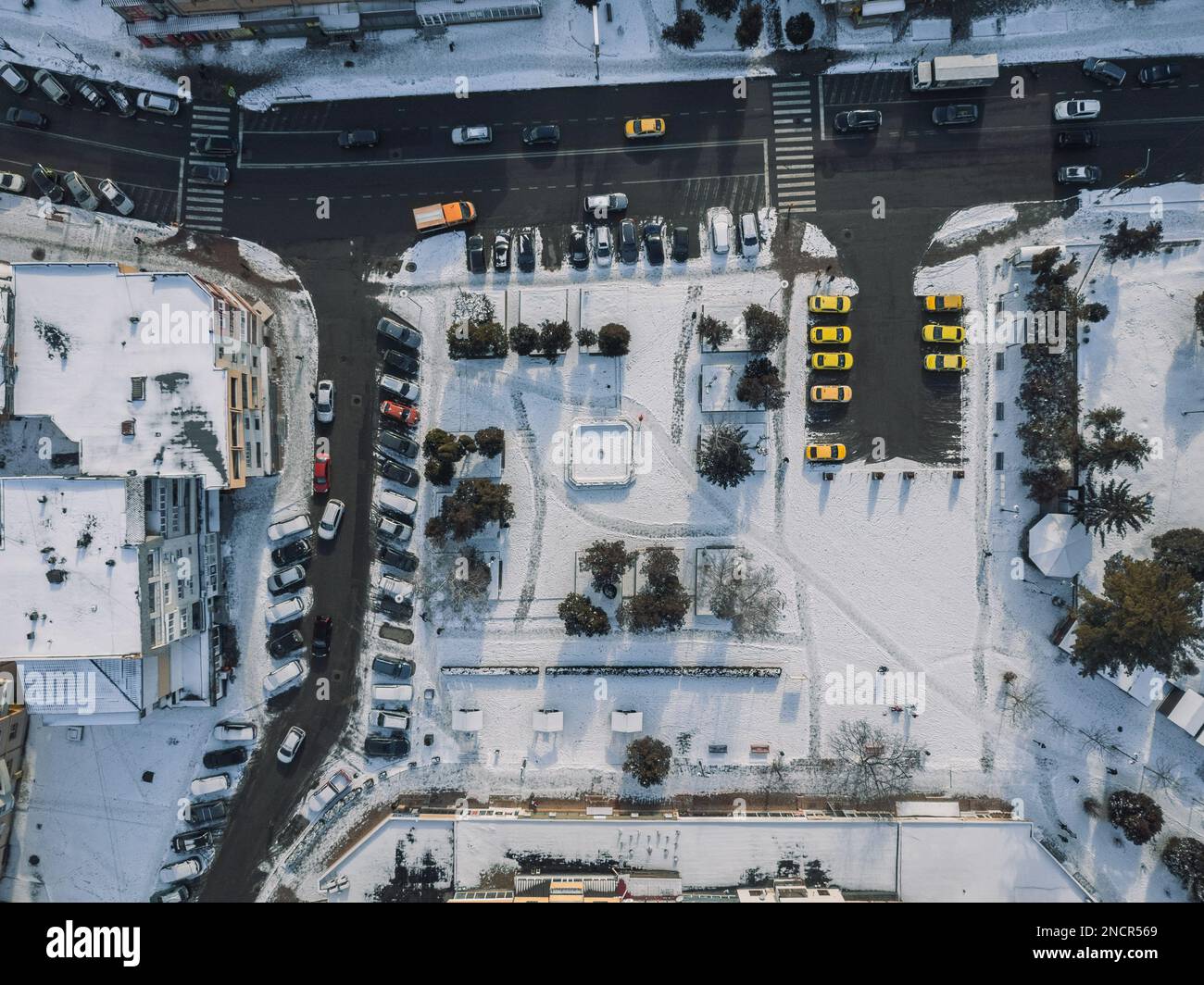 A bird's eye view of the cars driving on the road on the snowy town ...