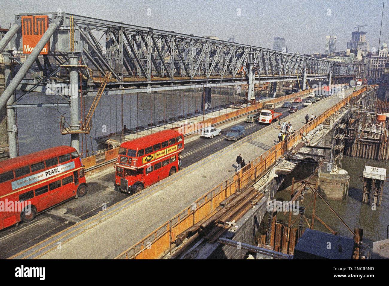 Red London buses travel over the new London Bridge which is under ...