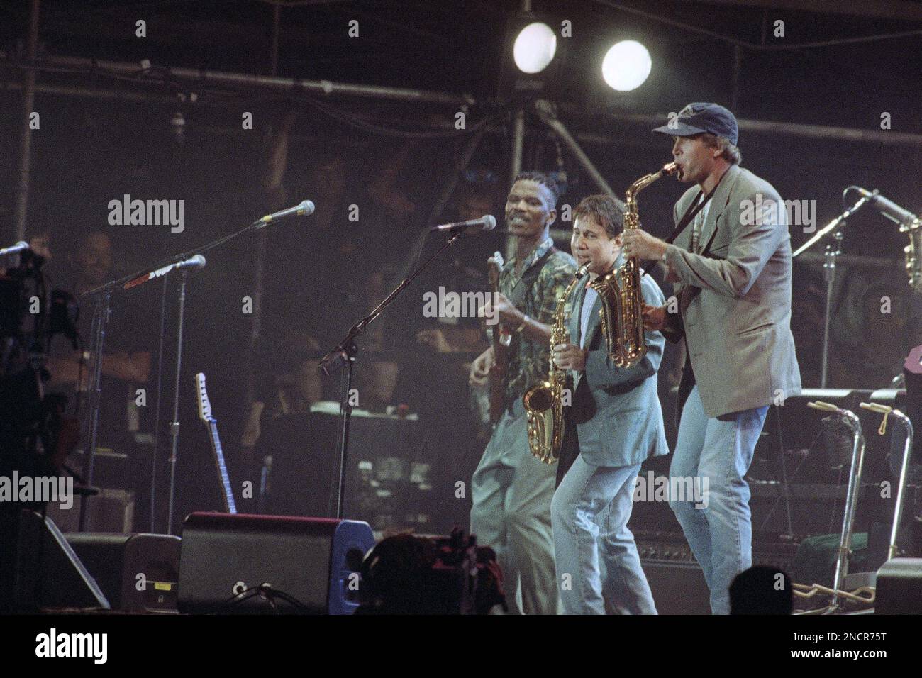 Paul Simon, center, does a finale with lead guitarist Ray Phiri, left ...