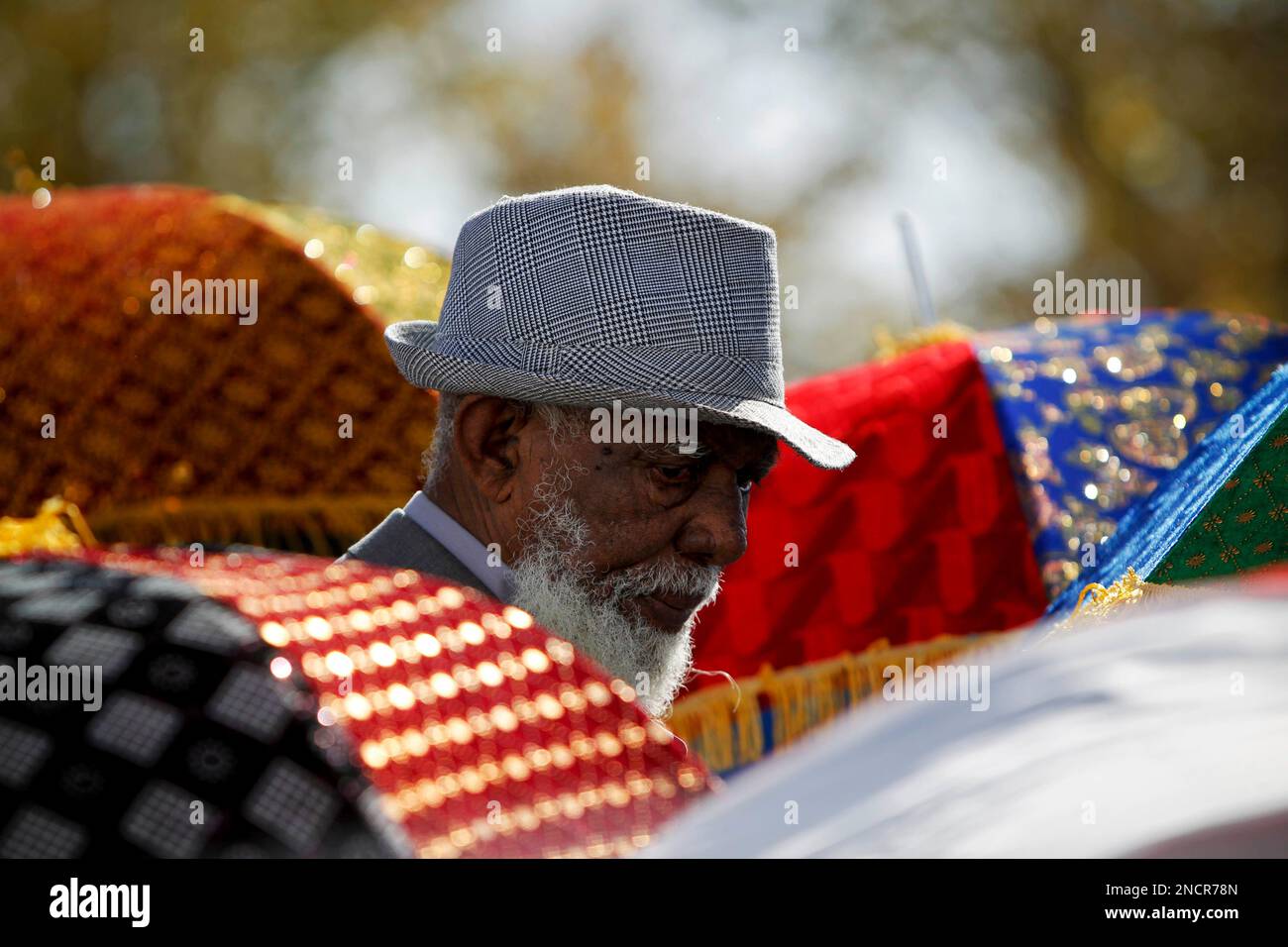 An Ethiopian Jewish man walks among colorful umbrellas during a ...