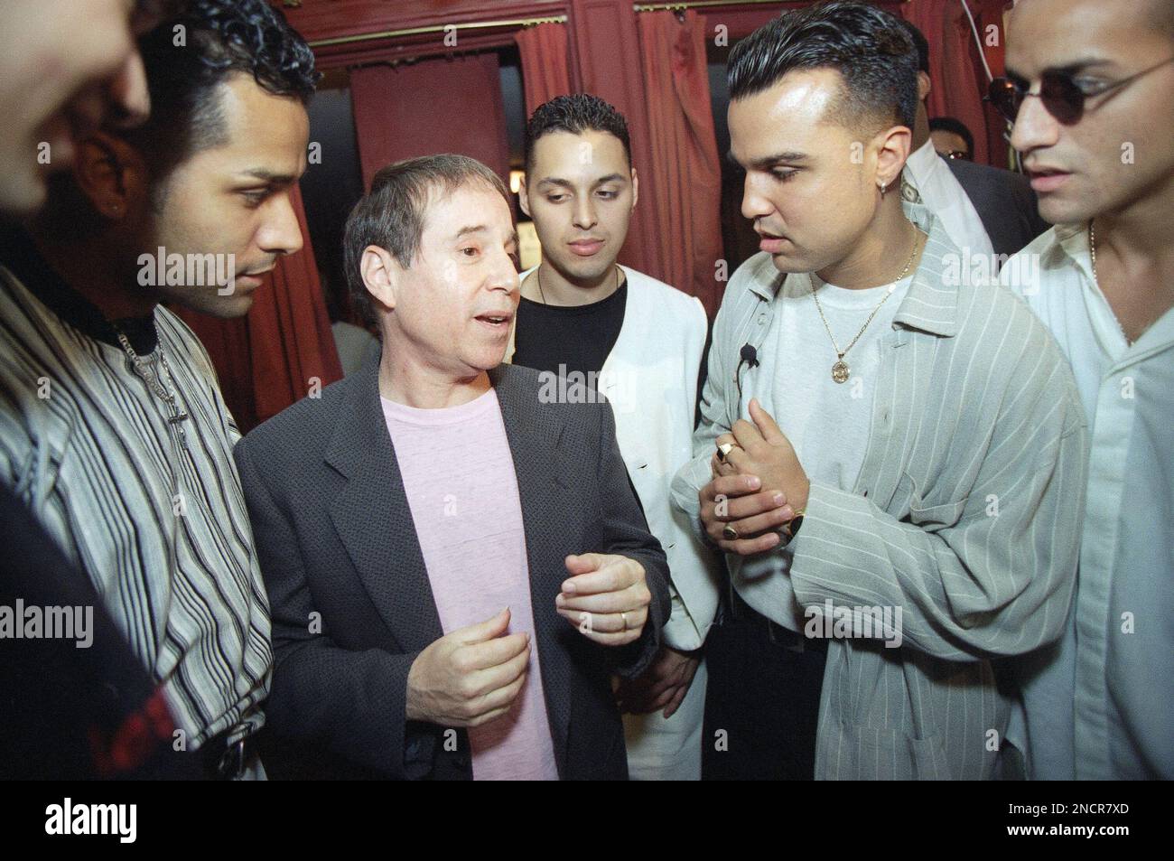 Paul Simon, center, talks with members of the Barrio Boyzz prior to ...