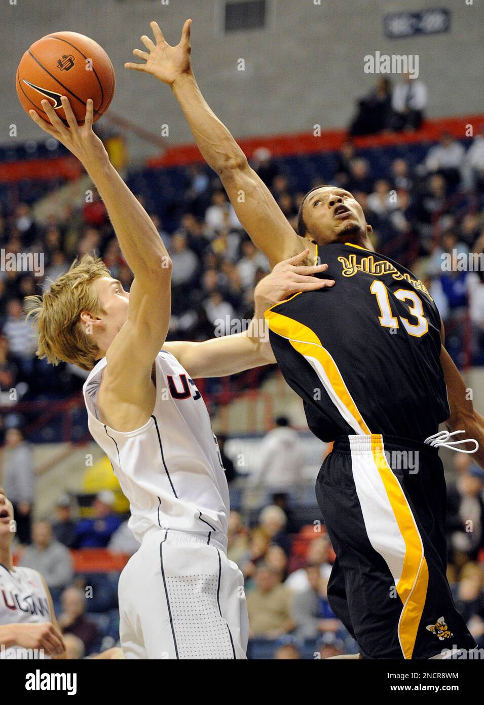 Connecticut's Niels Giffey, left, drives past American International ...
