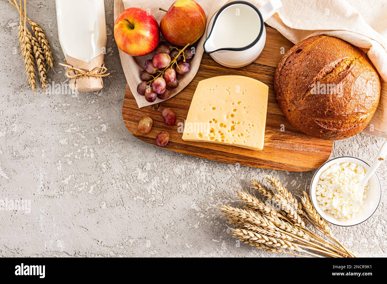 fresh dairy products, a loaf of bread, a bouquet of ears of corn ...