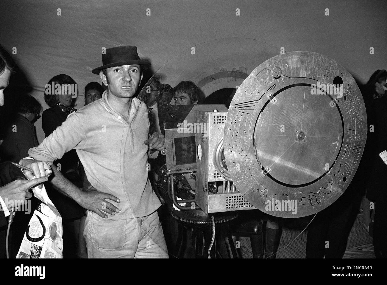 French artist Hans Walter Mueller stands beside the projector he uses ...