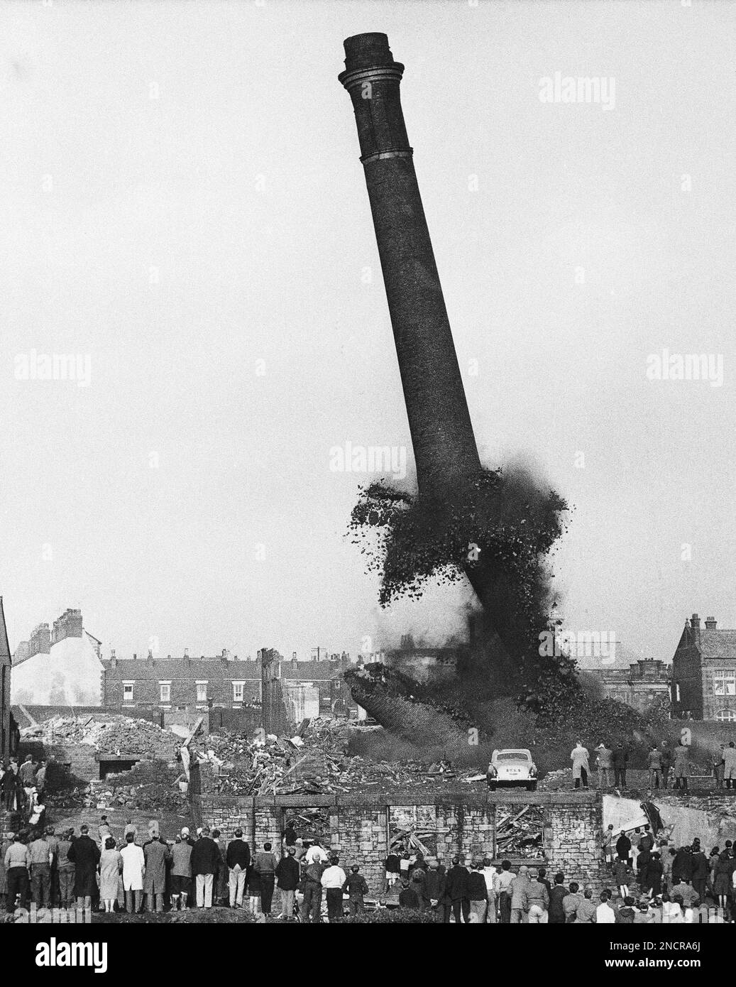 Split seconds after the detonation of a charge, a 250-foot chimney ...