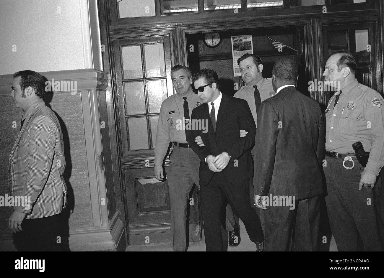Stanley B. Hoss, in dark glasses is escorted to court room from holding ...