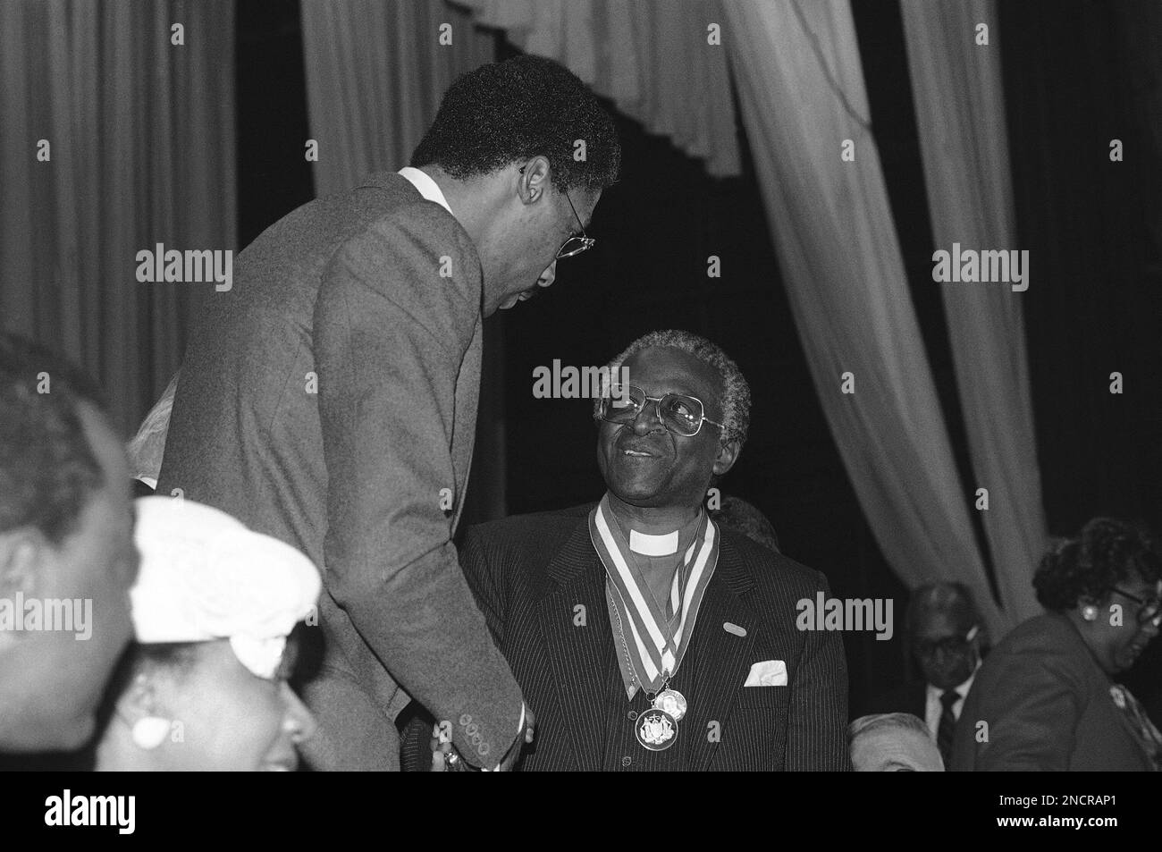 Bishop Desmond Tutu, right, is greeted by Philadelphia 76ers’ captain ...