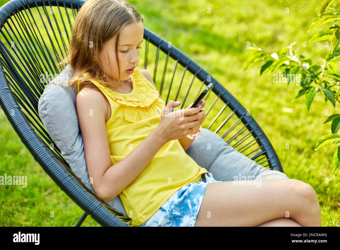 Happy kid girl playing game on mobile phone in the park outdoor, child ...