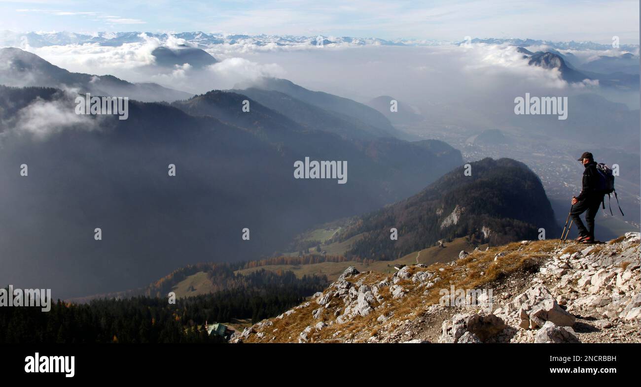 A hiker walks his way in front of the Alps during best sunny and warm ...