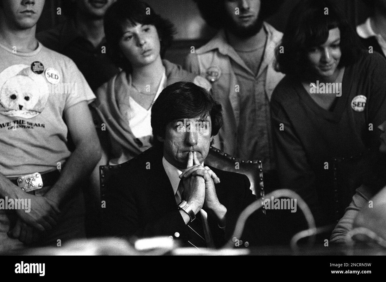 Activist Tom Hayden, seated, ponders comments during meeting with ...