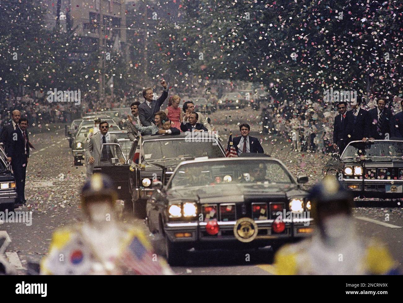 Paper confetti falls on the motorcade of President Jimmy Carter and ...