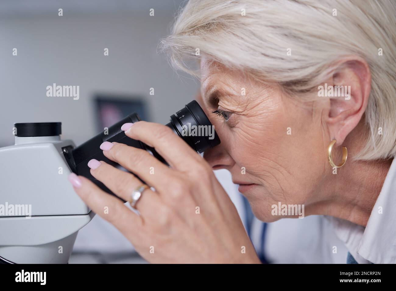 Microscope, doctor and senior woman in laboratory for research ...