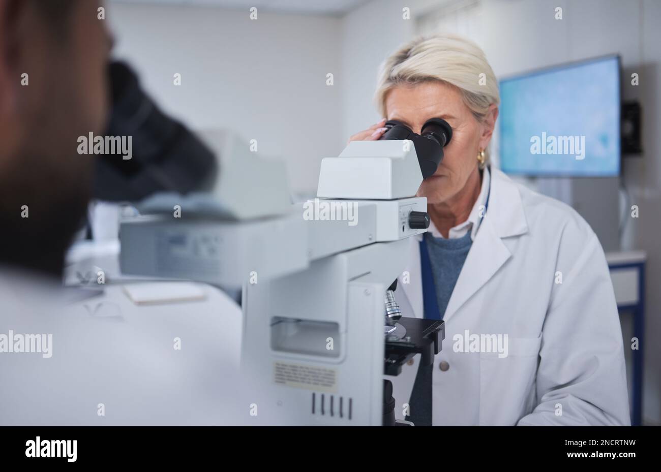 Mature woman, science or laboratory microscope in medical research ...
