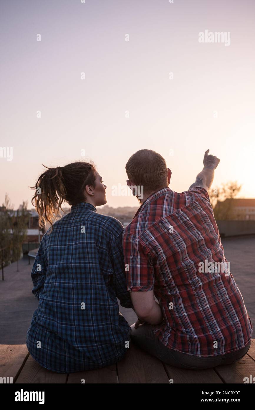 Romantic date on roof. Couple watching sunset Stock Photo - Alamy