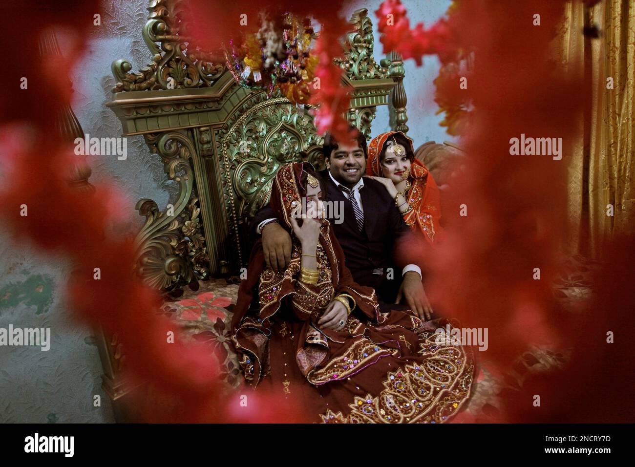 Pakistani Azhar Haidri, center, poses for a picture with his wives ...