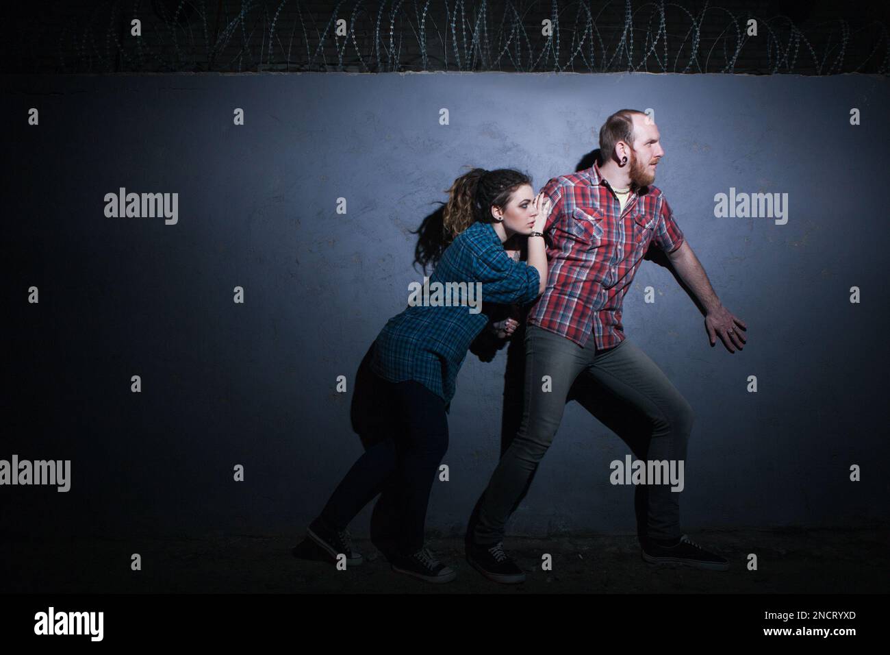 Scared criminal couple. Prison background Stock Photo - Alamy