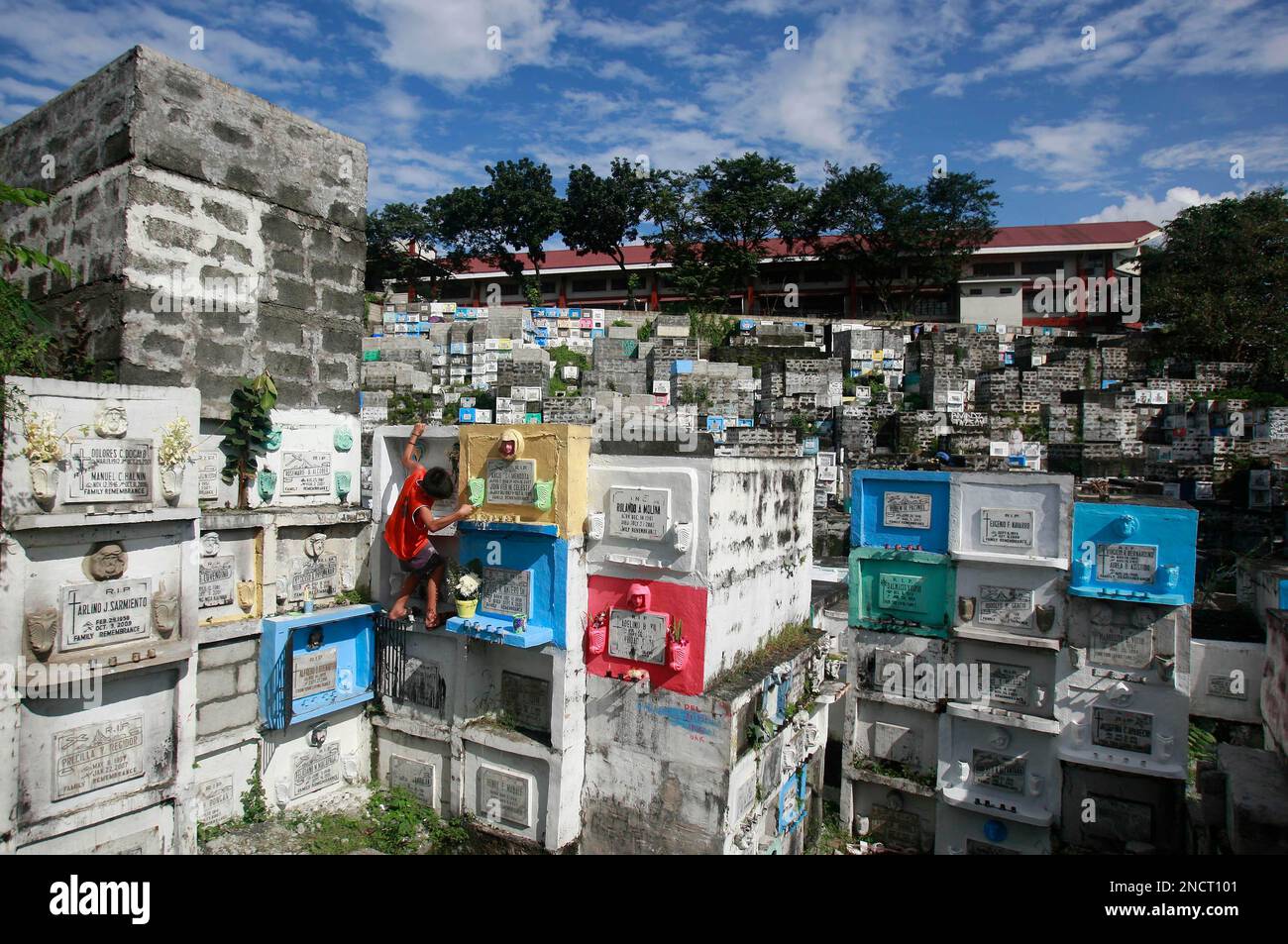 A Filipino boy paints a tomb at a public cemetery as they prepare for ...
