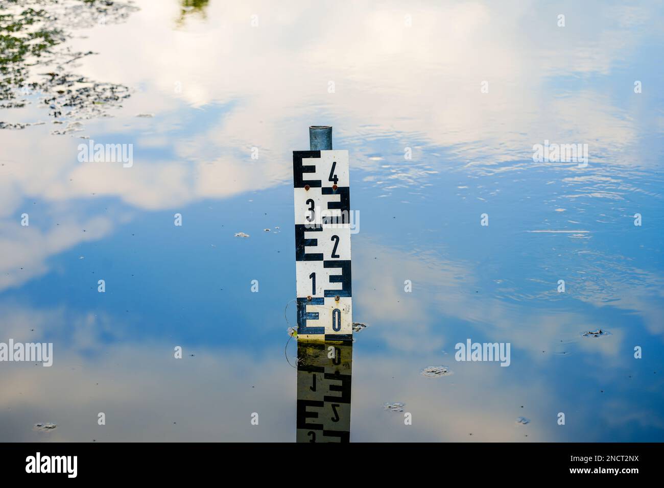 Level meter on a lake with clouds reflected on the water surface Stock ...