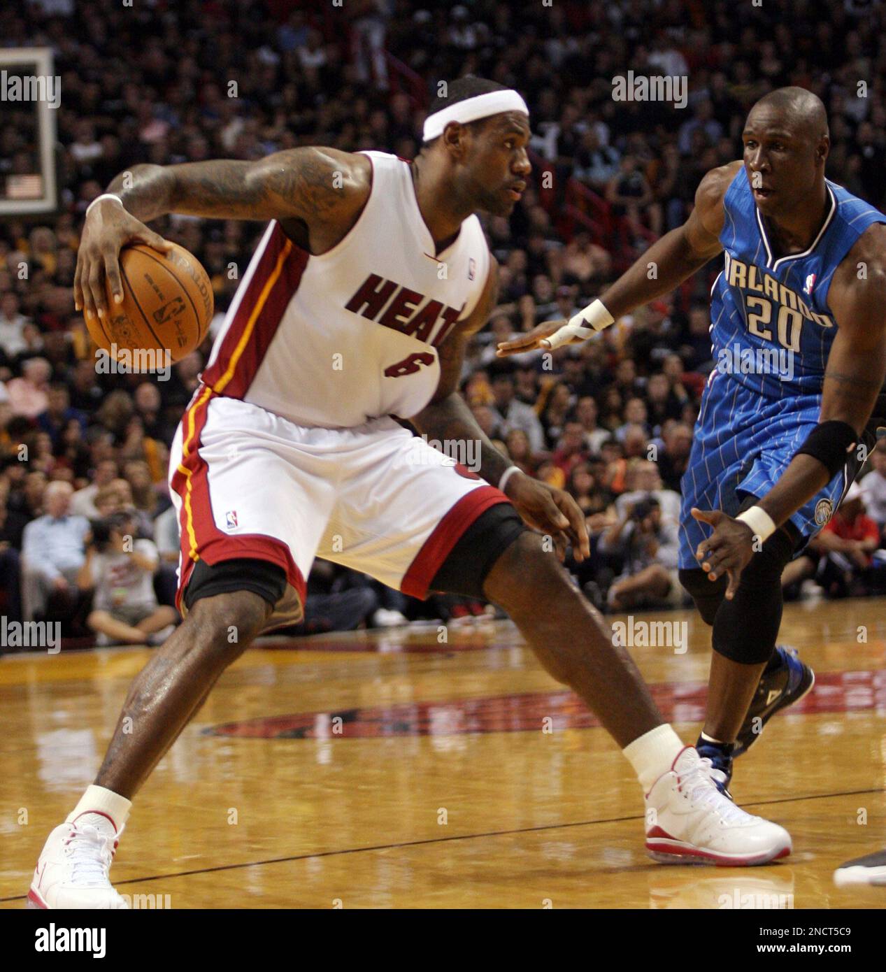 Miami Heat's LeBron James, left, controls the dribble as Orlando Magic ...