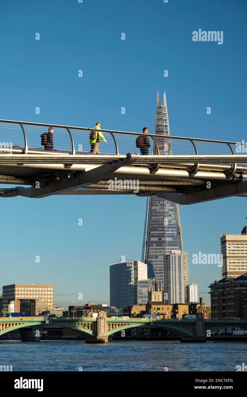 Mid shot of pedestrian bridge across Thames in London with Modern ...