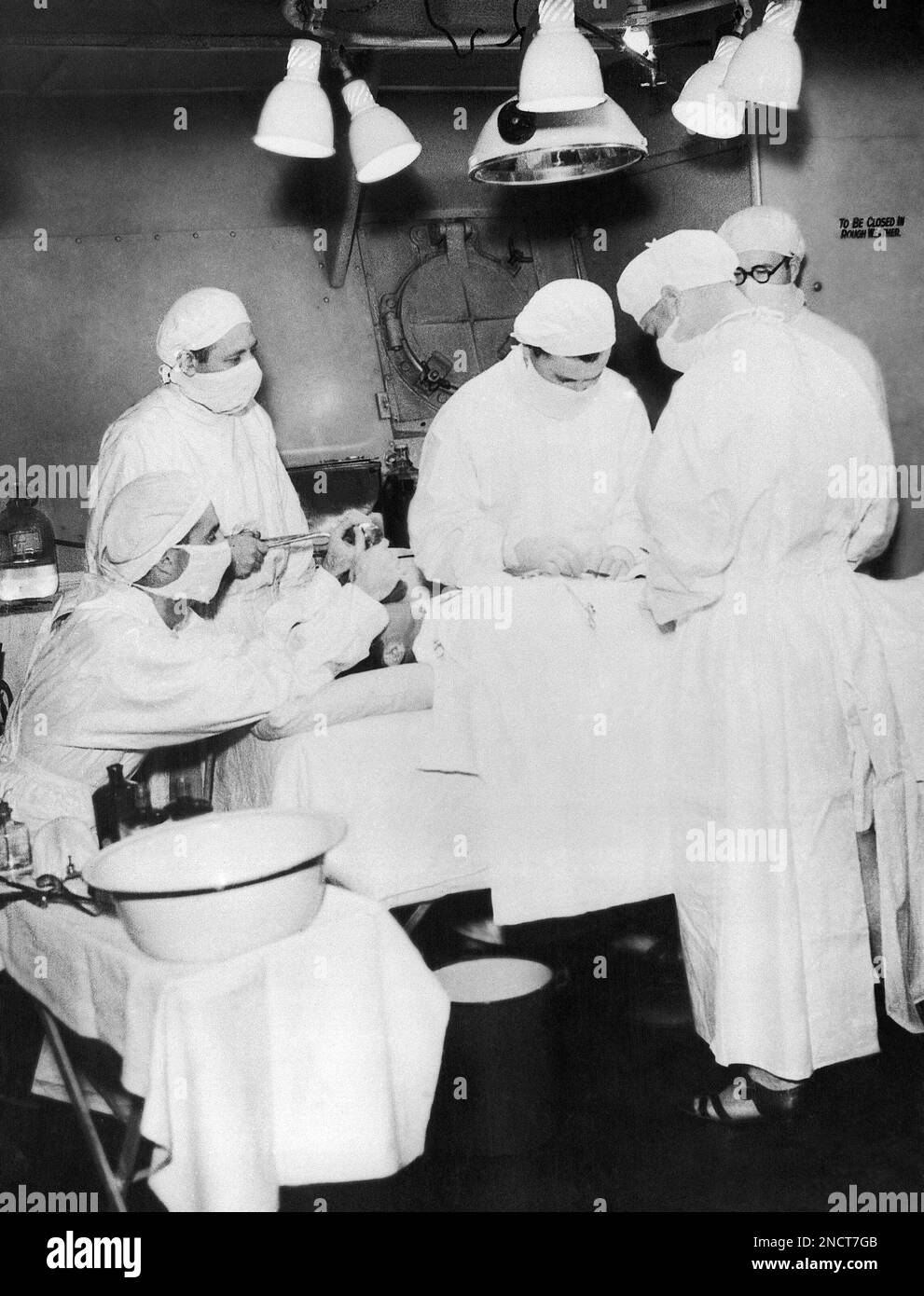 Doctors aboard the British cruiser H.M.S. Kenya perform an appendectomy ...