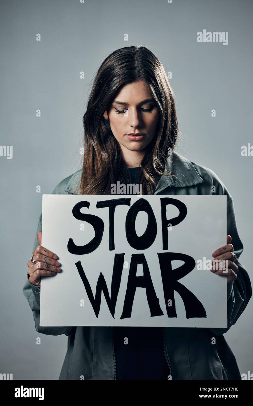 War, stop and sad woman with a sign as a voice isolated on a grey ...