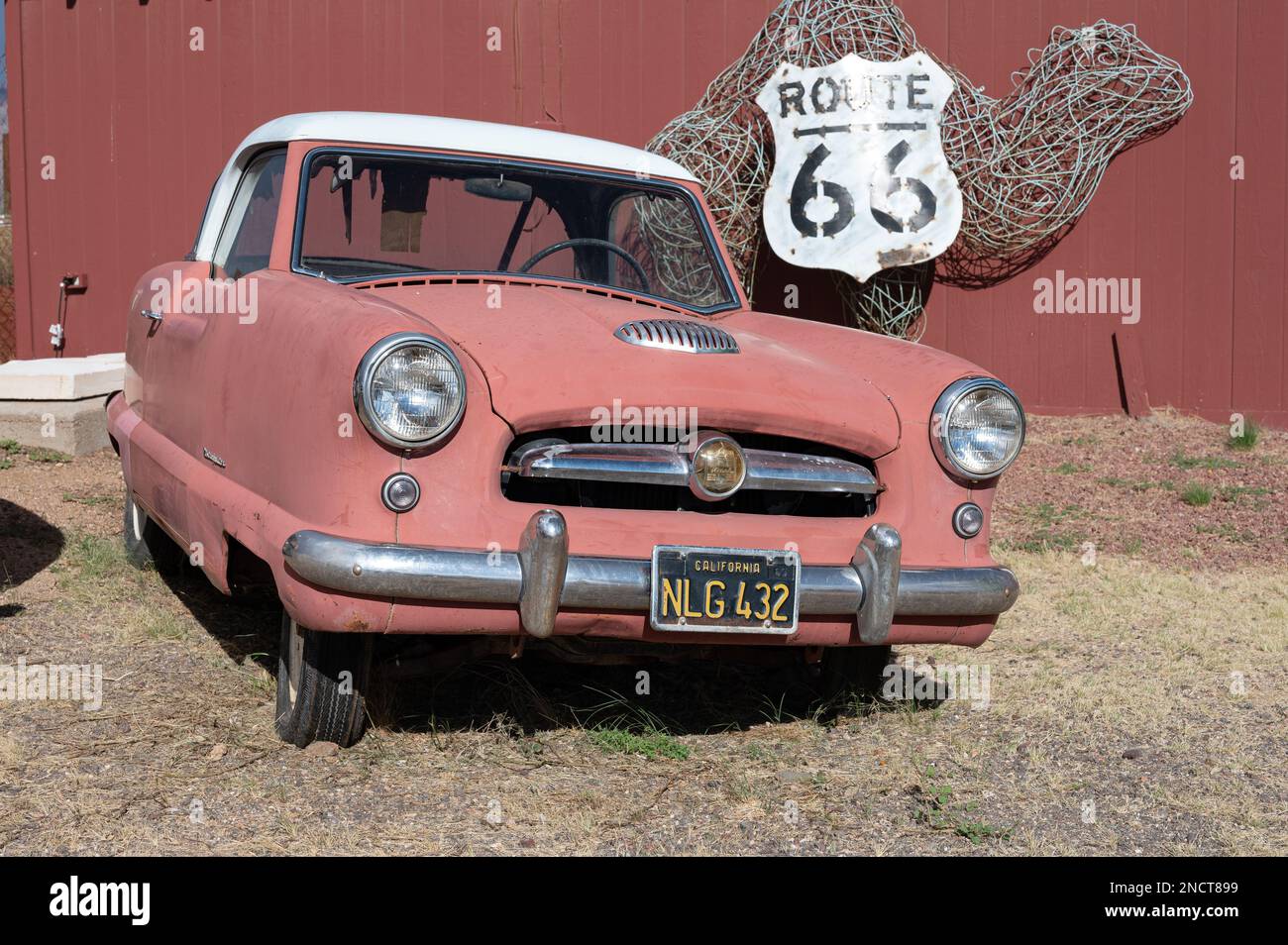 An old urban small car abandoned on a farm, it's a red Nash ...