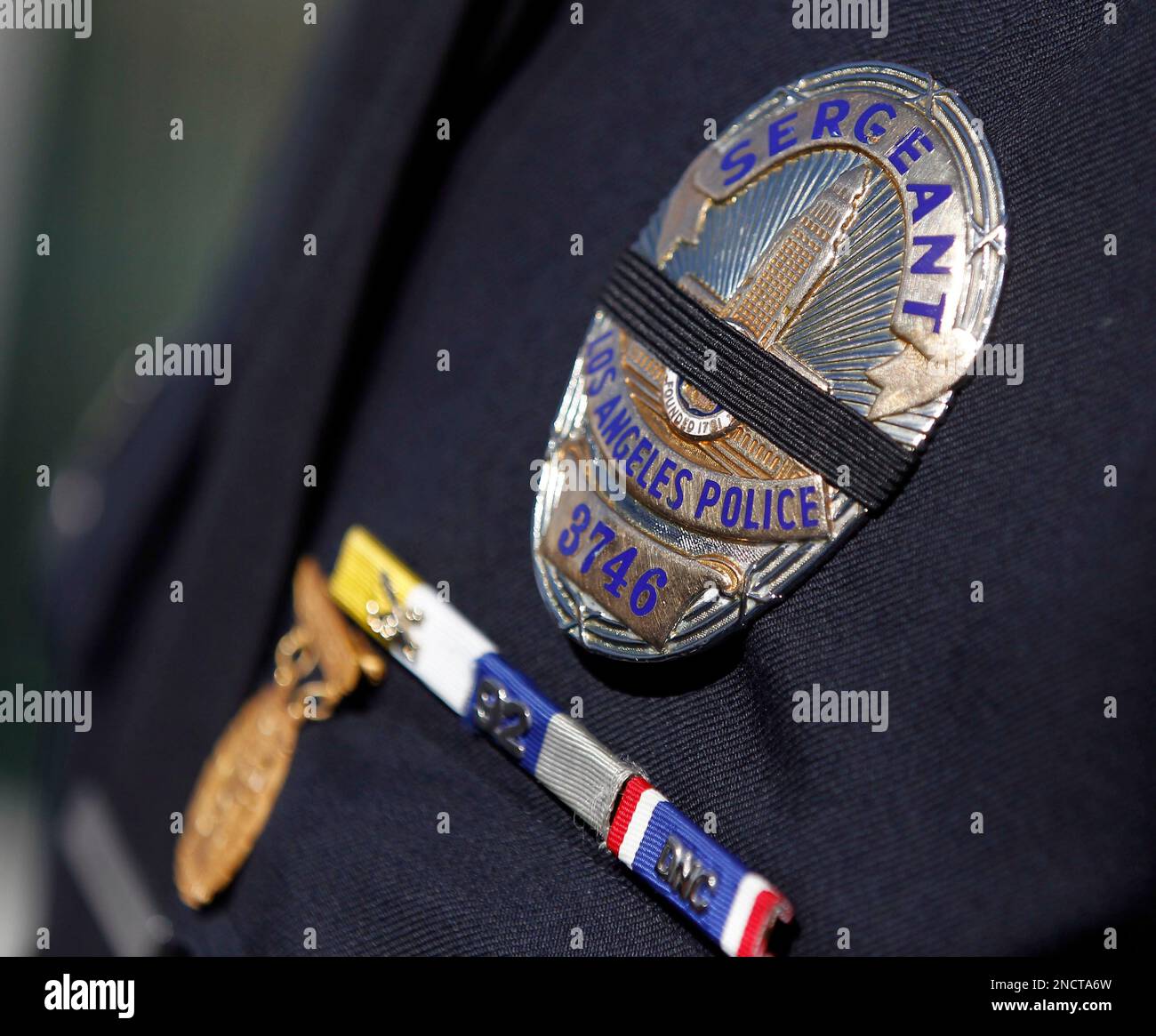 The badge of LAPD officer is covered with a black band on honor of ...