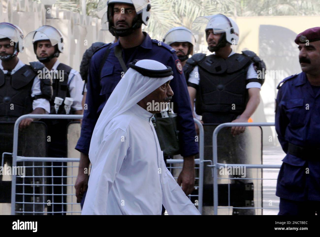 An unidentified Bahraini man passes rows of riot police Thursday, Oct ...