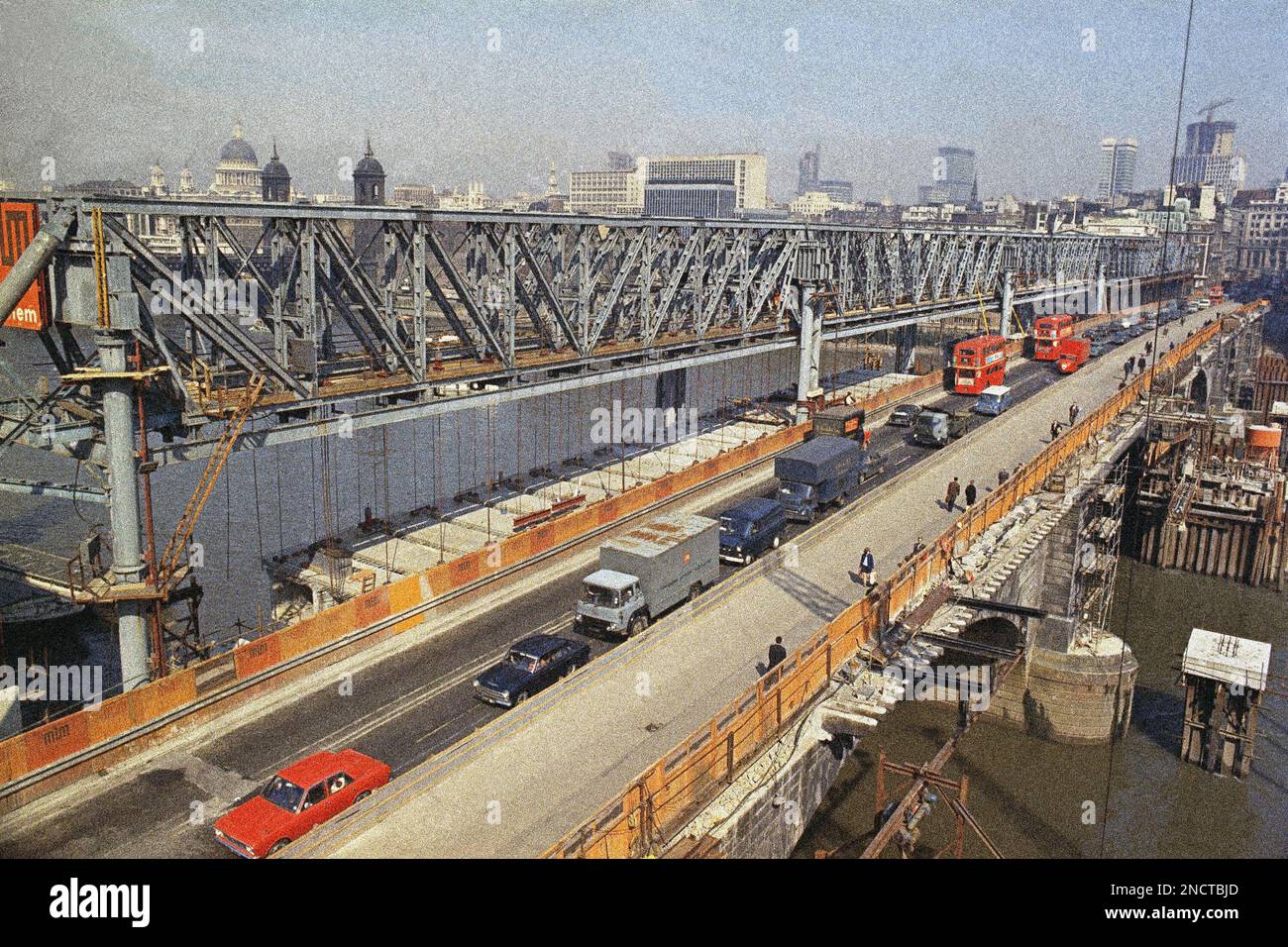 Traffic and people travel over the new London Bridge which is under ...
