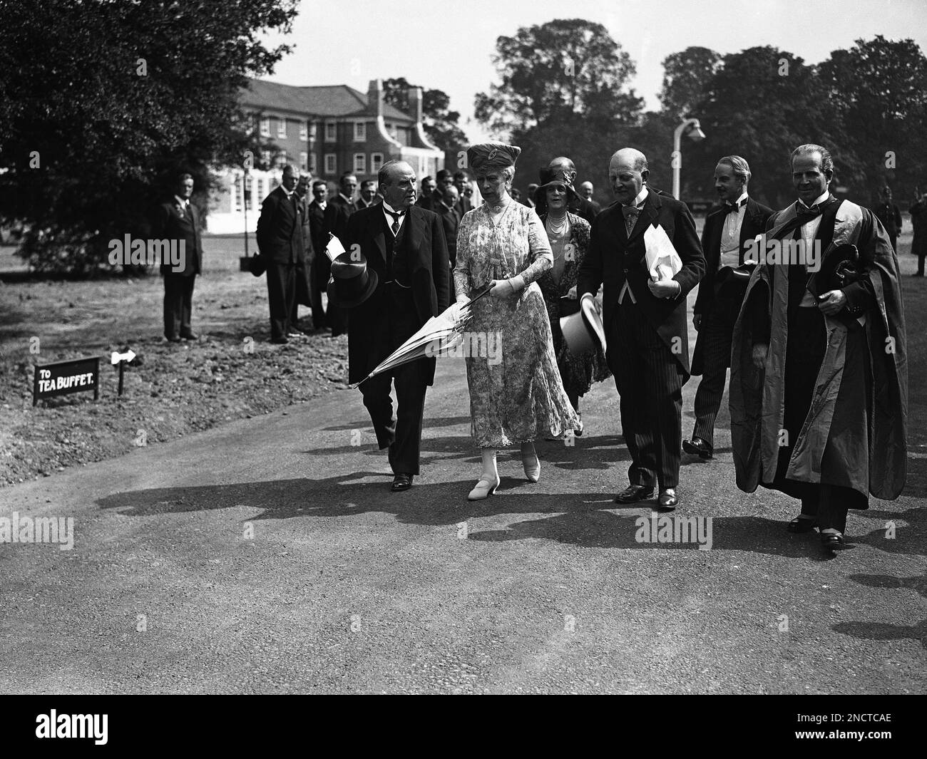 Britain's Queen Mary carrying a parasol as she walks through the ...