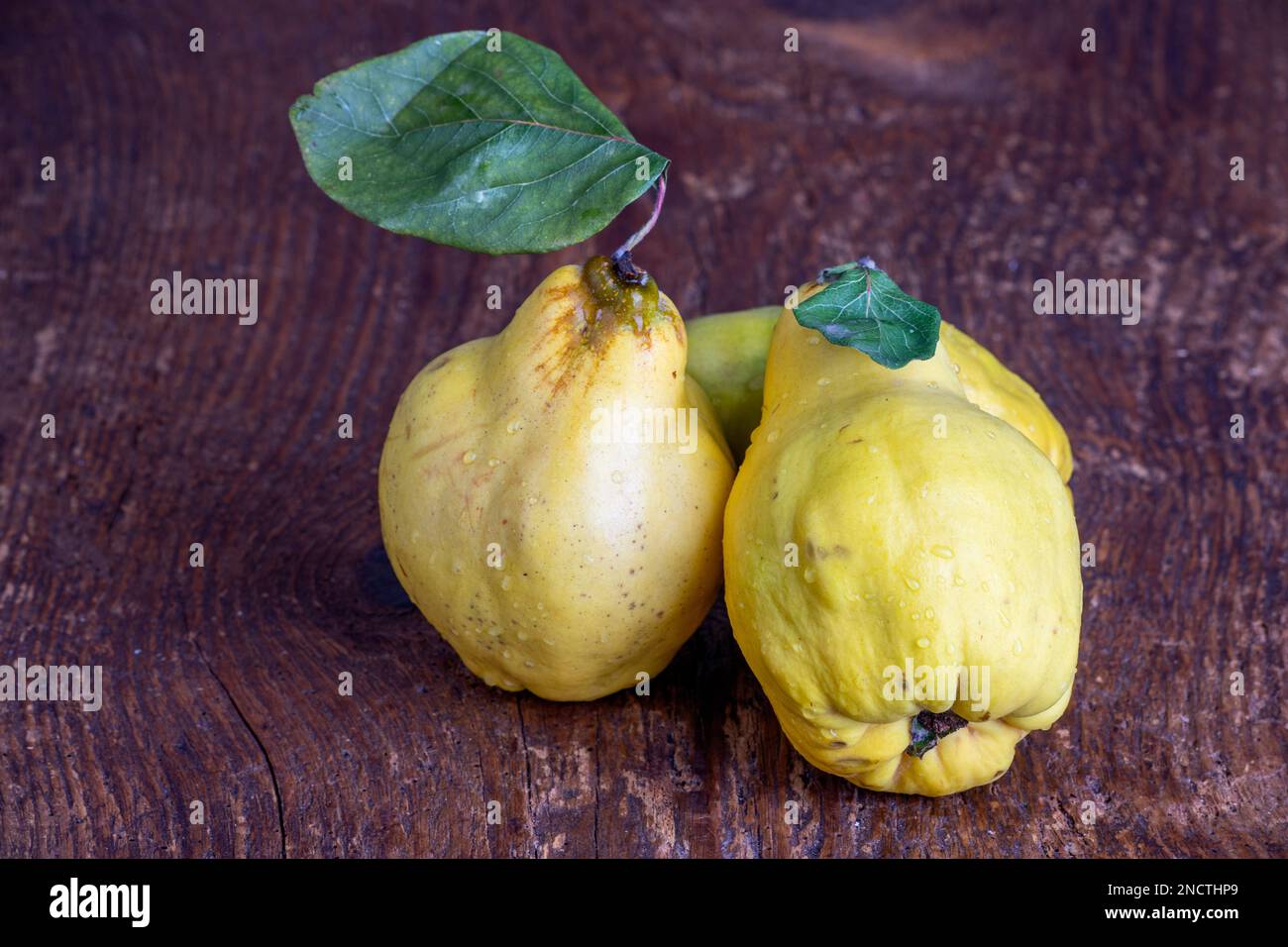 Raw Quince On Dark Wood Stock Photo - Alamy