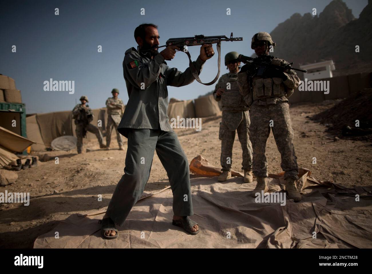 An Afghan policeman gets weapons training with US soldiers from 2nd PLT ...