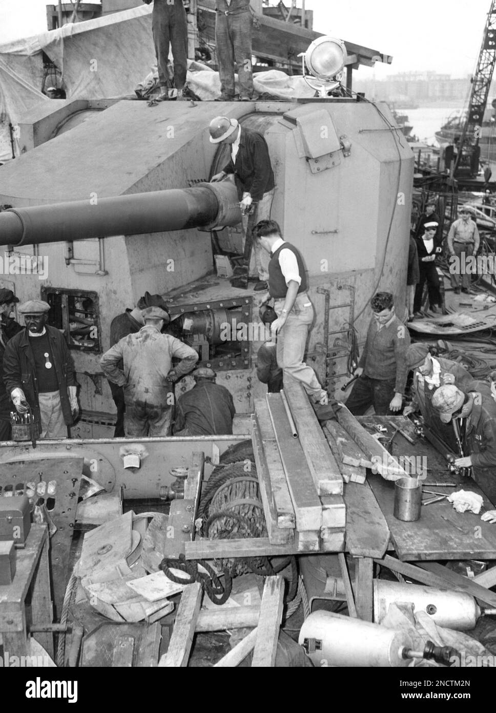 Workmen from the U.S. Navy Yard at Brooklyn swarm over the turret of H ...