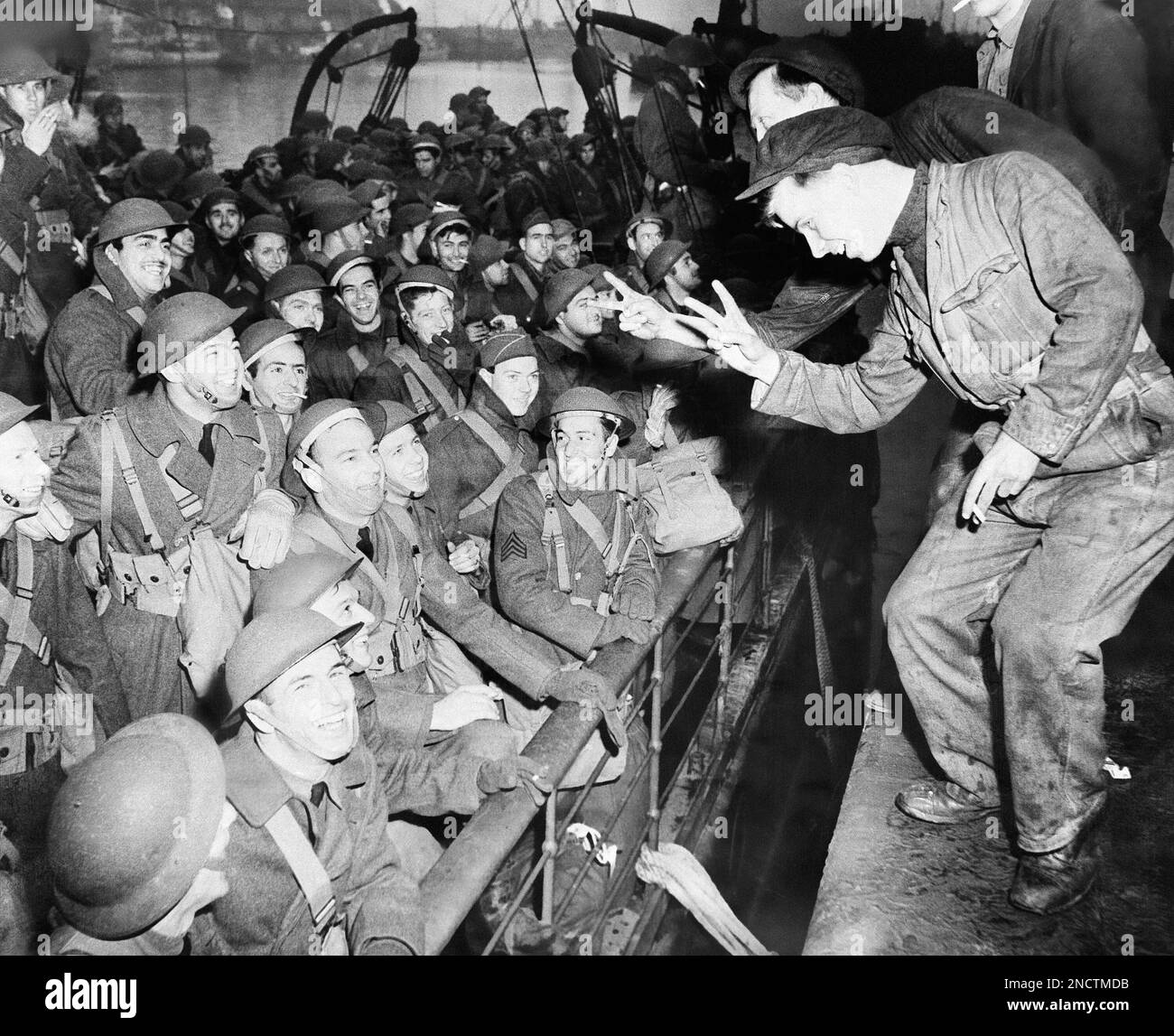 Two Ulster lads lean over side of a pier and greet American soldiers ...