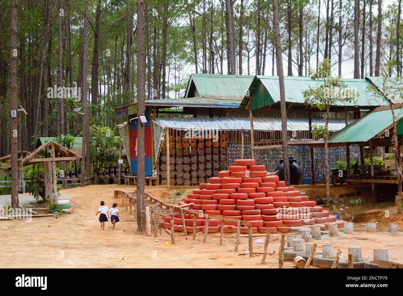 Students run across the yard at Coconut School, which is built from ...