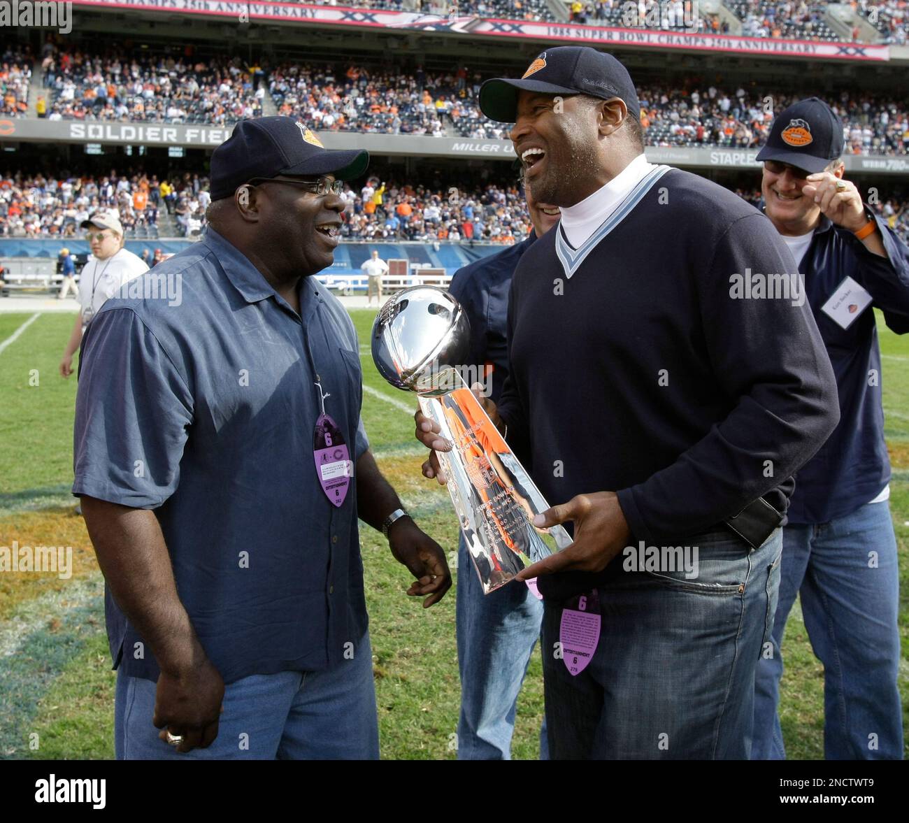 Chicago Bears' Richard Dent, right, carries the Super Bowl Trophy past ...