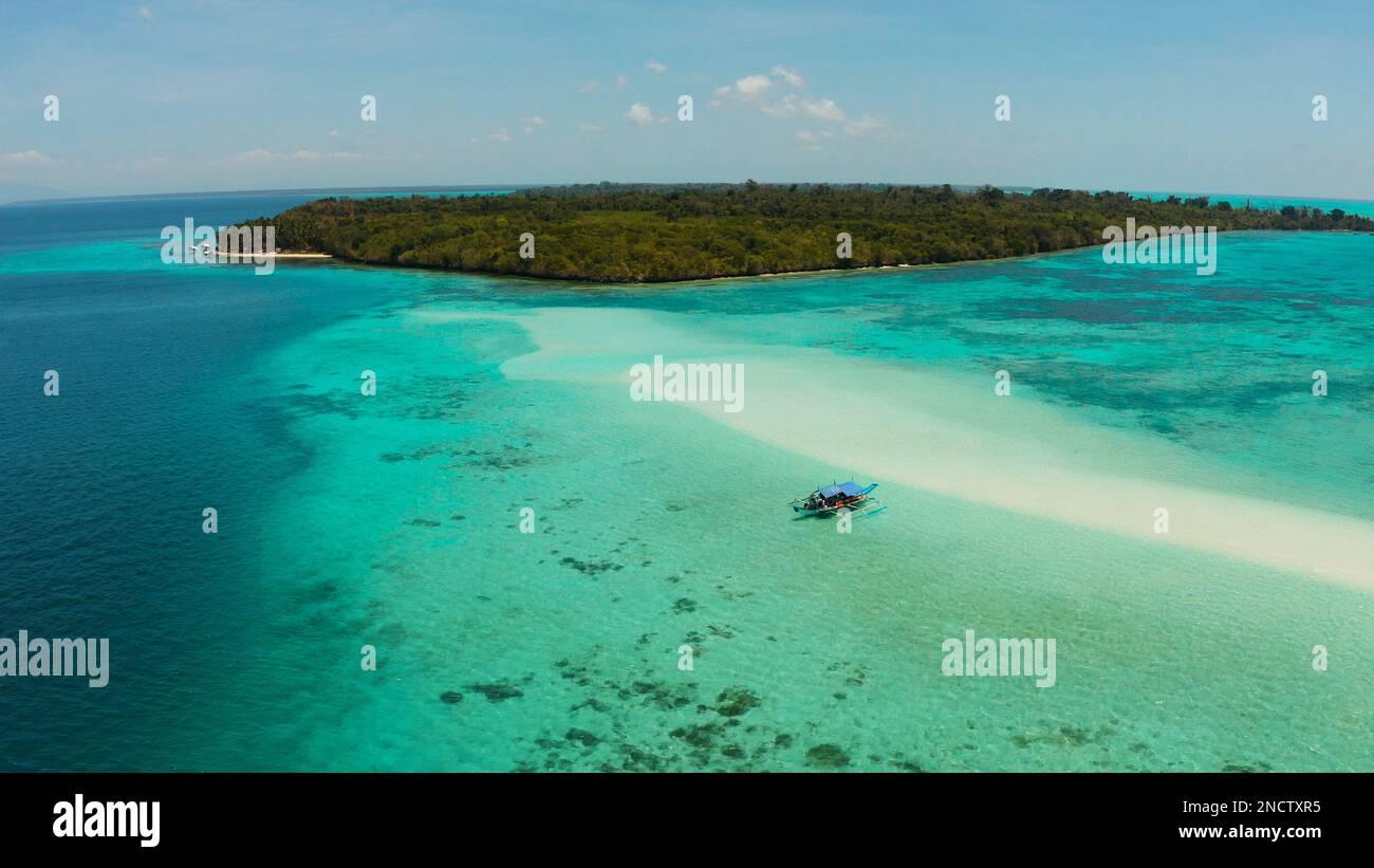 Travel concept: sandy beach on a tropical island by coral reef atoll ...